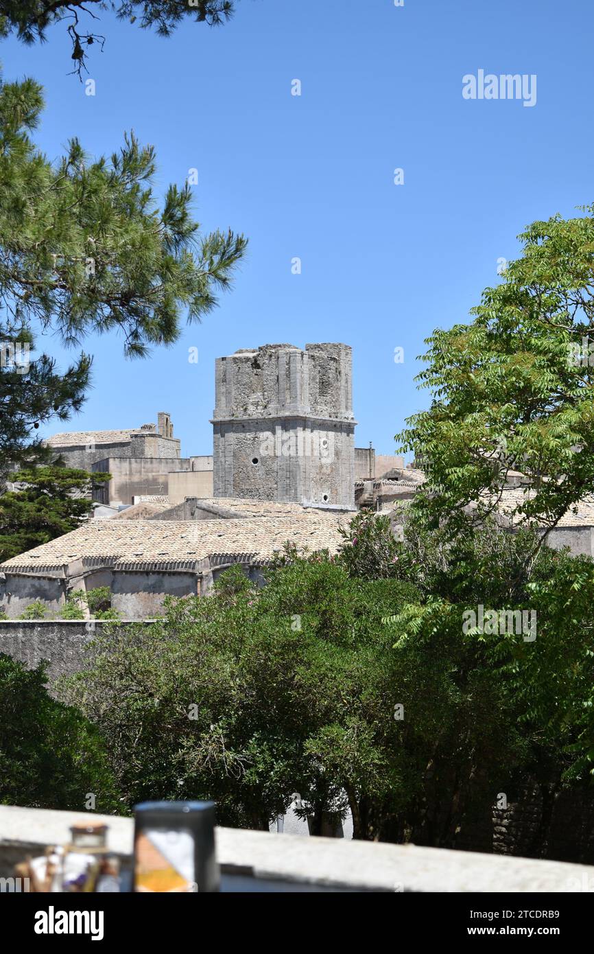 Traditional roofs and houses surround a stone tower with demolished ...