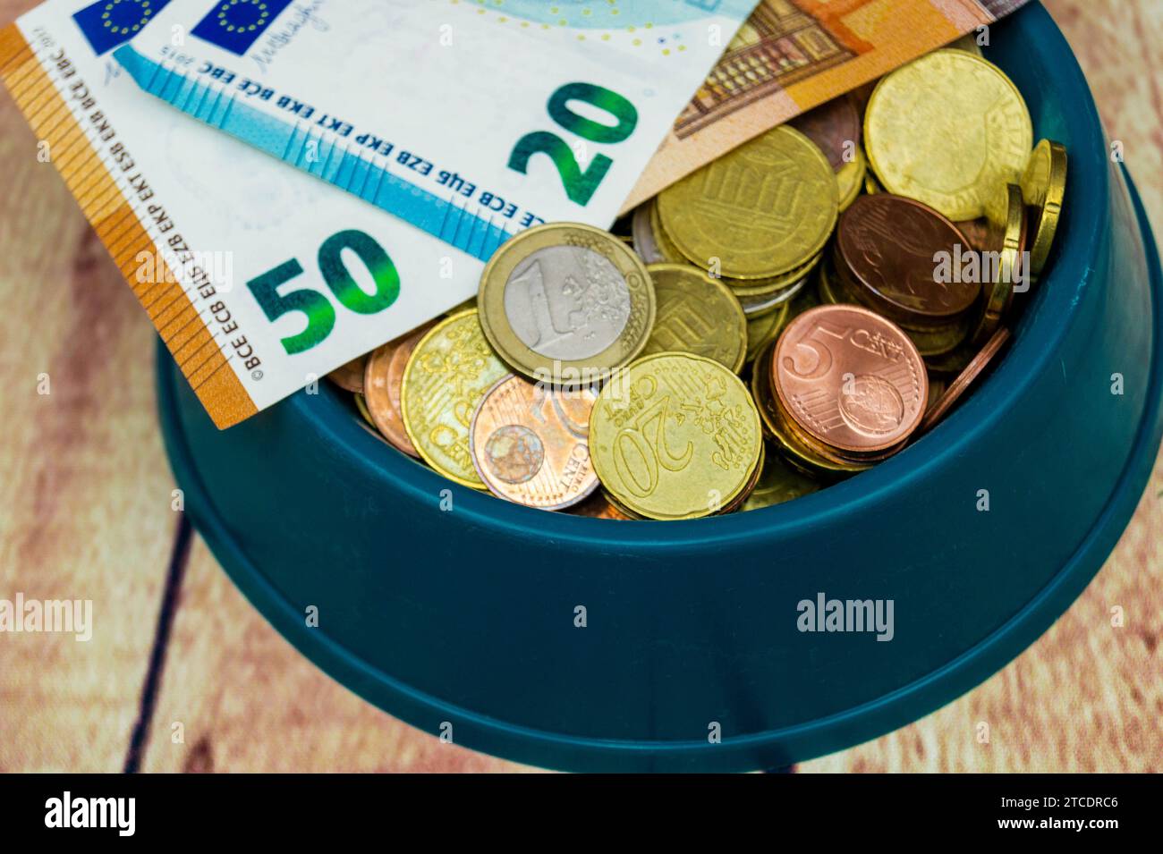 coins and banknotes in the feeding bowl, symbol for feeding costs Stock ...