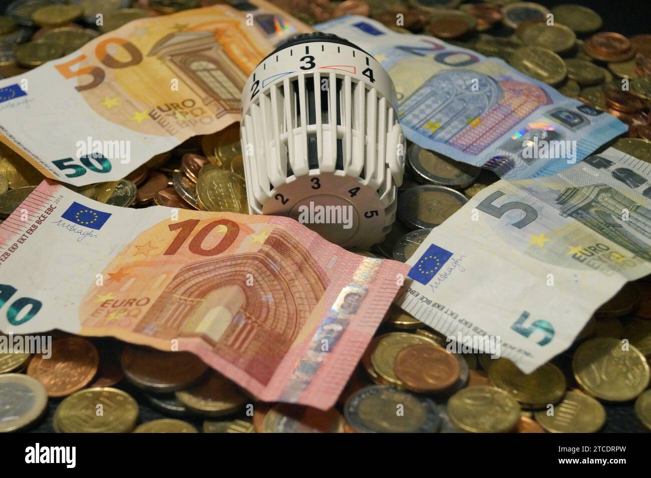 thermostatic valve of a heater with Euro bills and coins, symbol ...