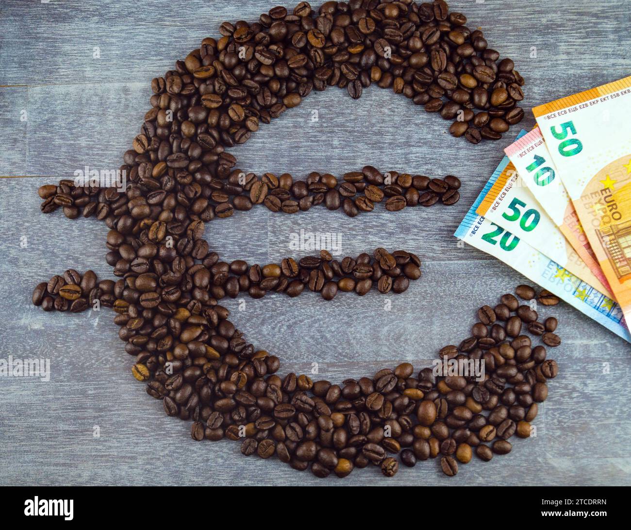 Euro sign, formed with roasted coffee beans, with Euro bills, coffee ...