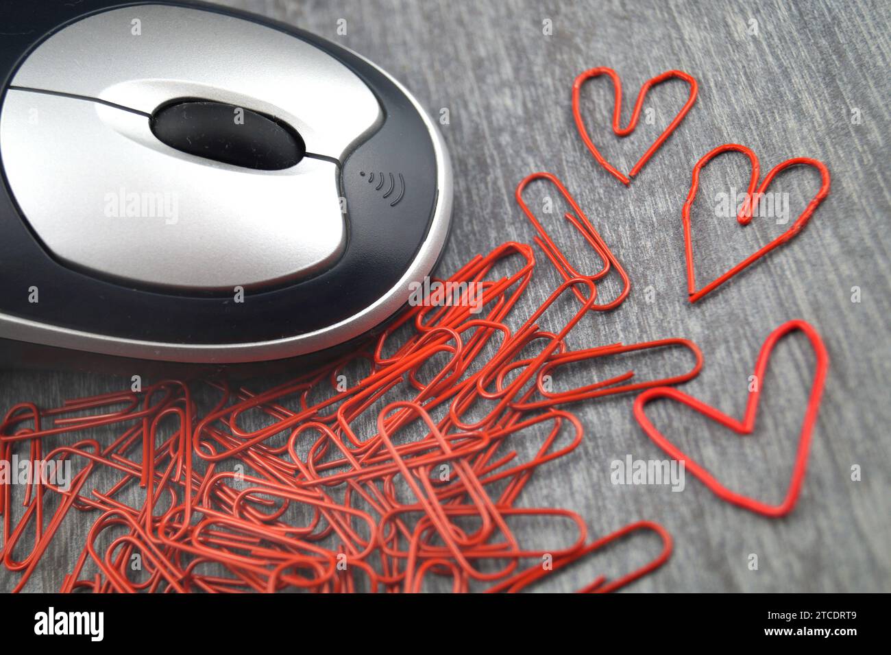 computer mouse with red paper-clips, three of them heart-shaped, love ...
