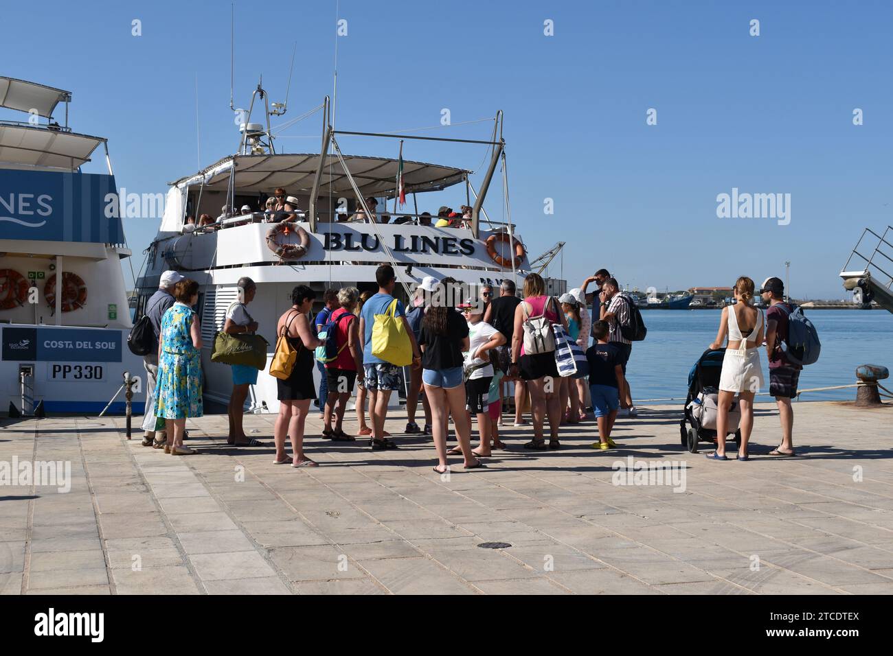 Group of tourists in the port of Trapani boarding the Blu Lines cruise ...