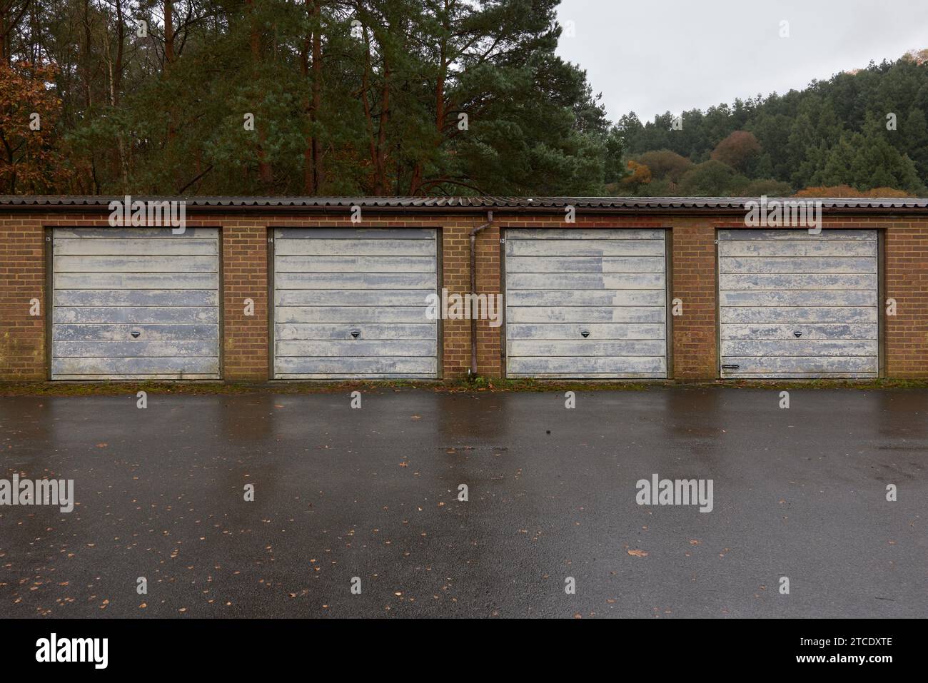 Old Worn Abandoned Garages with aluminium doors with a tarmac road ...
