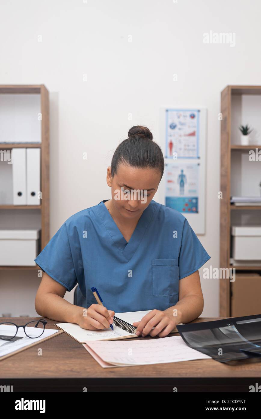 doctor in a blue uniform diligently reviews and organizes medical ...