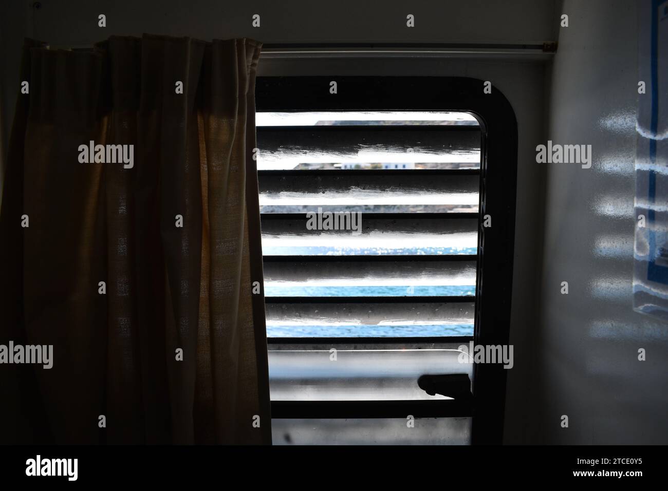 Light shining through the wooden blinds in a ship cabin with yellow ...