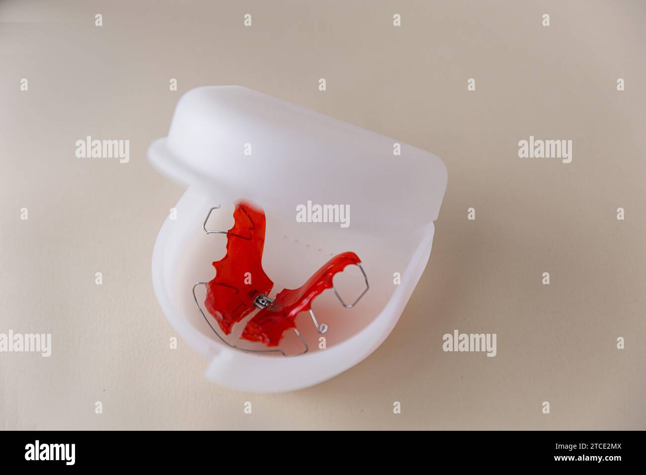 Red retainer or jaw expander on the background. Crooked teeth ...