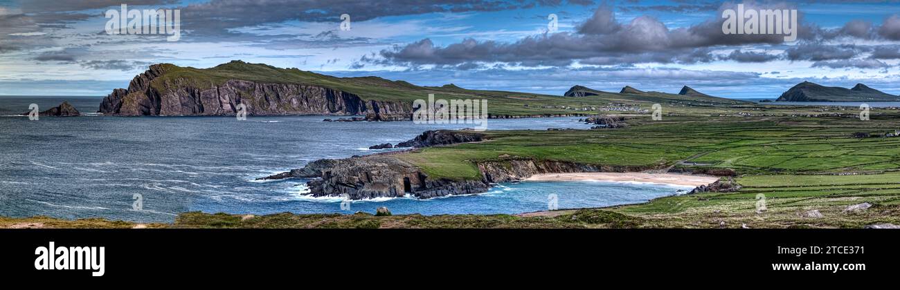 An idyllic outdoor scene with a rocky shoreline, lush grass, and a deep ...