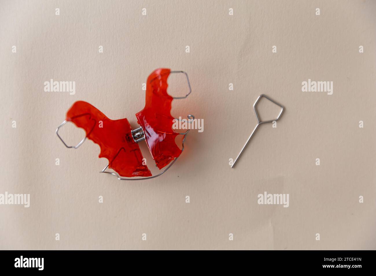 Red retainer or jaw expander on the background. Crooked teeth ...