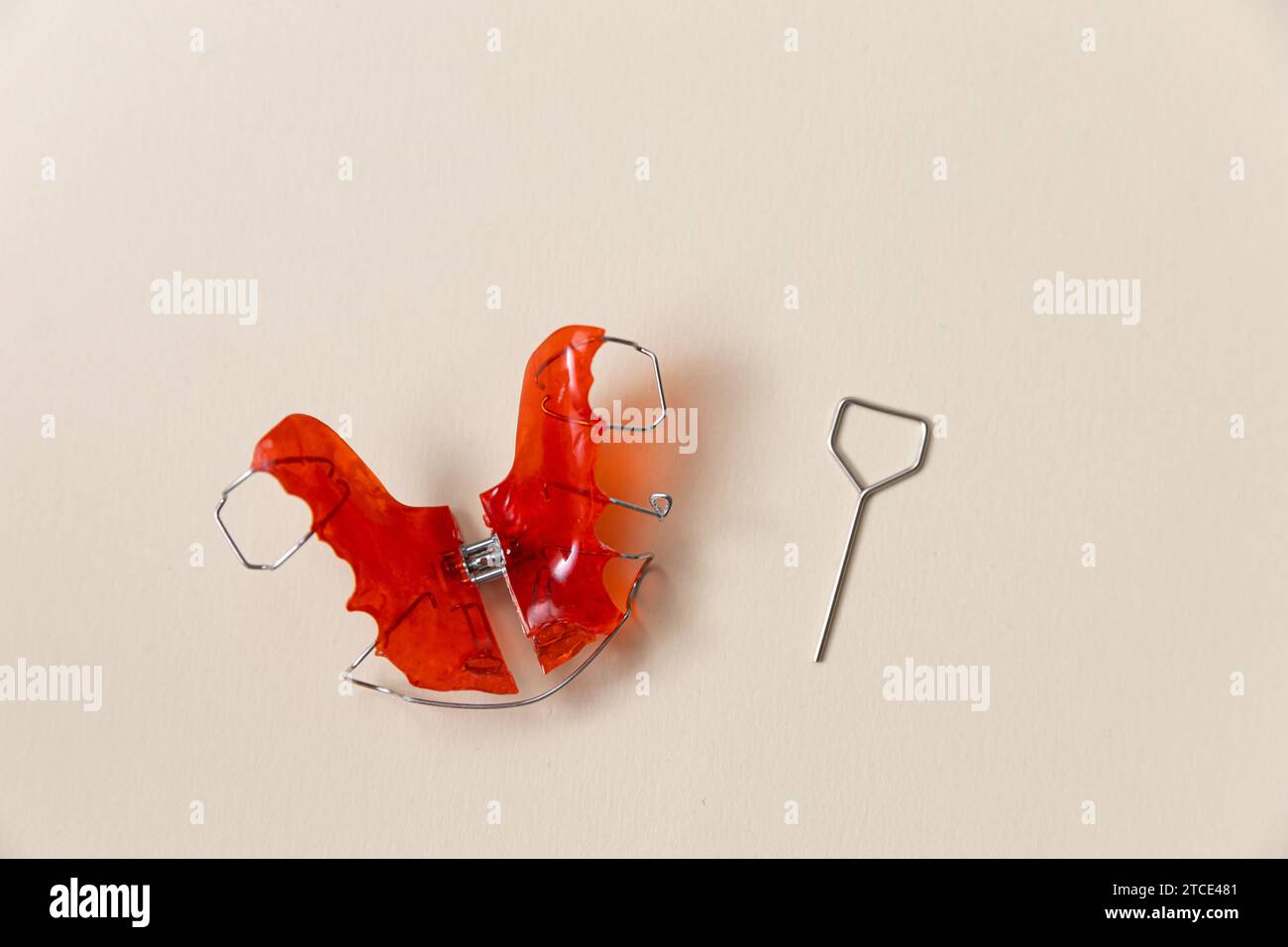 Red retainer or jaw expander on the background. Crooked teeth ...