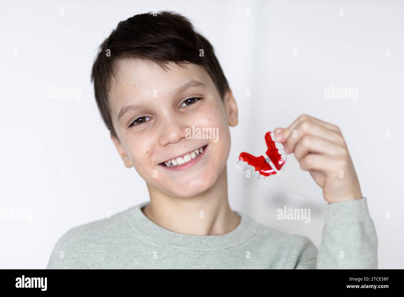 Boy smiling with tooth retainers in hand. Concept of crooked teeth ...