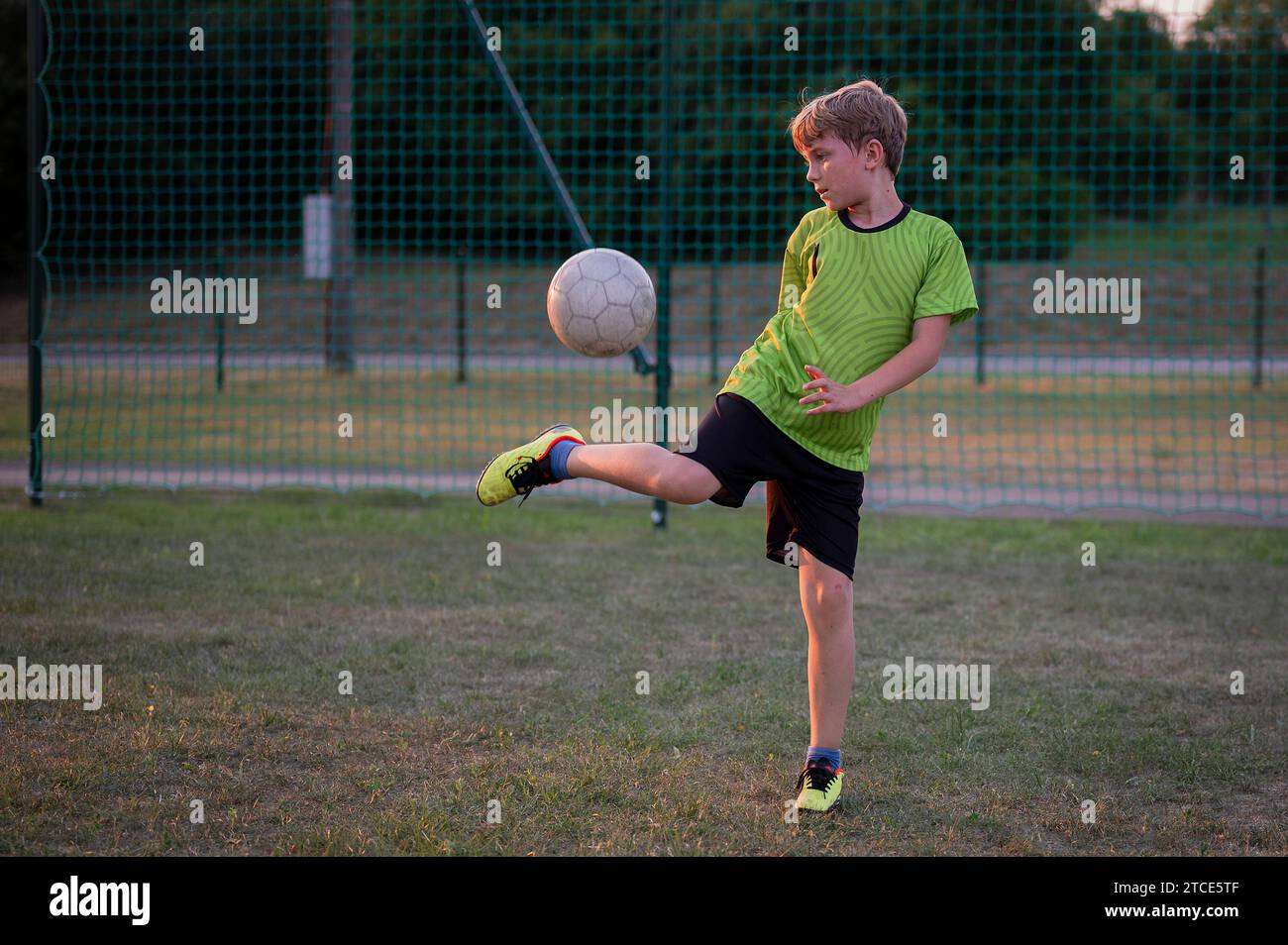 Young boy trains football at the pitch Stock Photo - Alamy