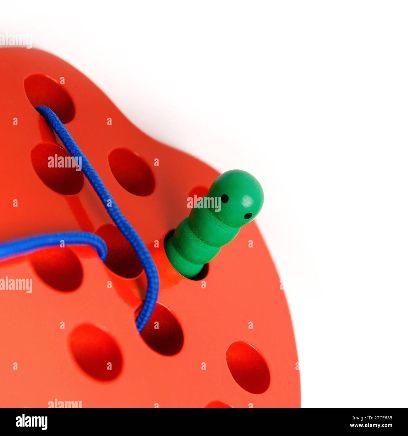 Kid's wooden toy in the shape of a red apple with a funny worm on a ...