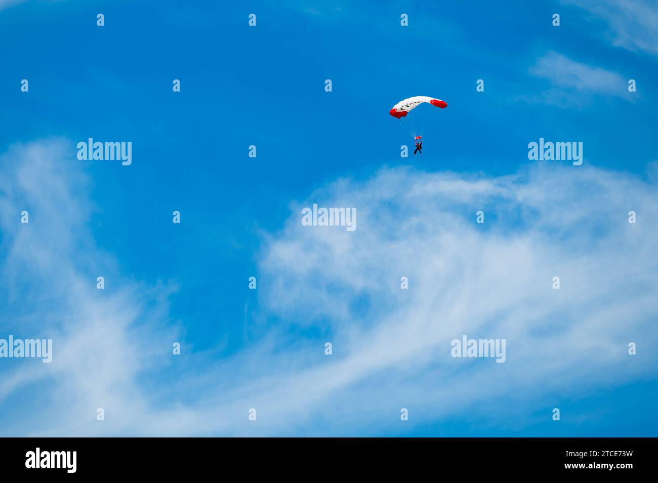 Parachutist with a white and red parachute against the blue sky Stock ...