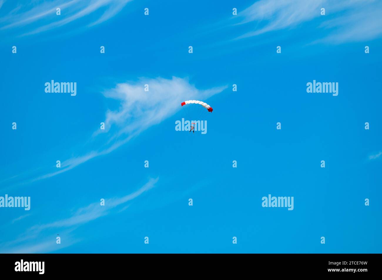 Parachutist with a white and red parachute against the blue sky Stock ...