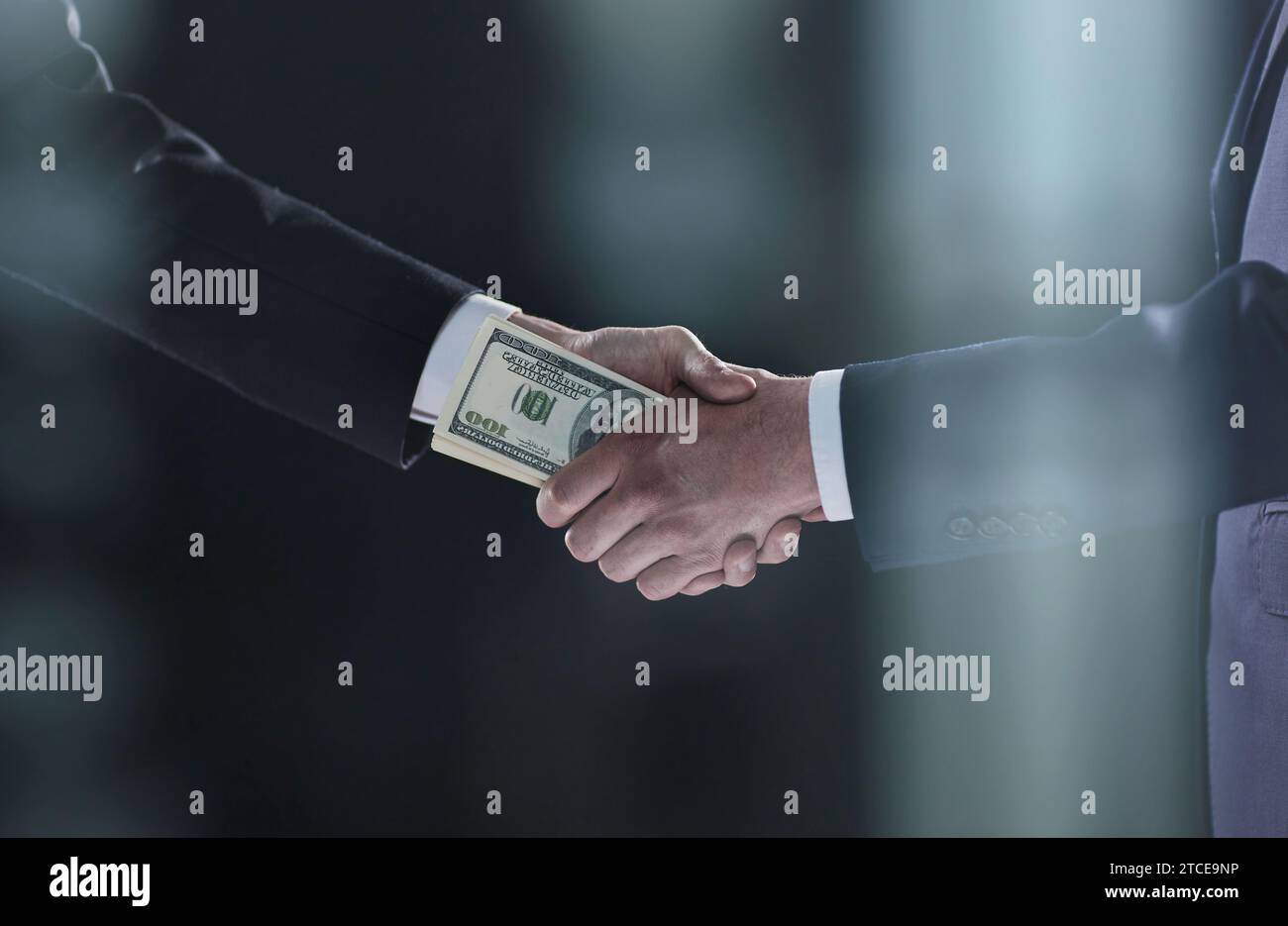 Handshake with the transfer of money on a black background Stock Photo ...
