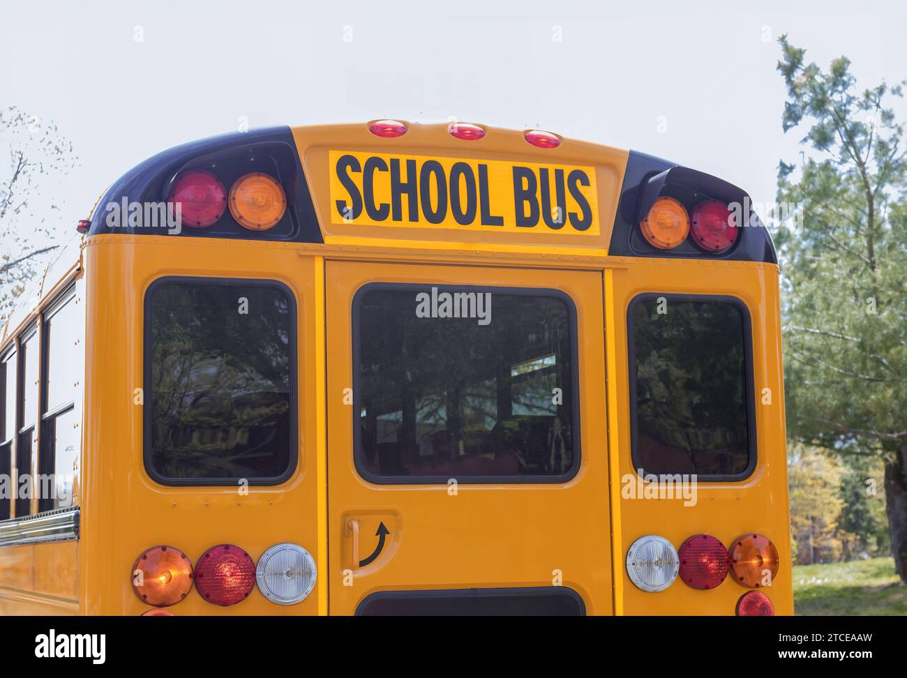 An orange school bus drives along street in suburban sleep area Stock ...