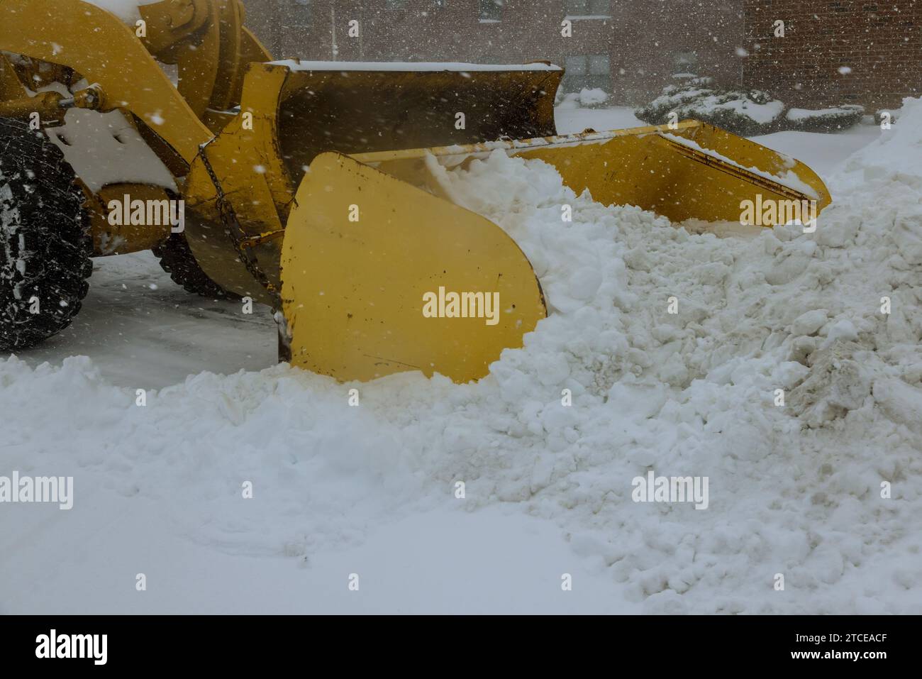 This snow plow truck removing snow from parking lot during heavy ...