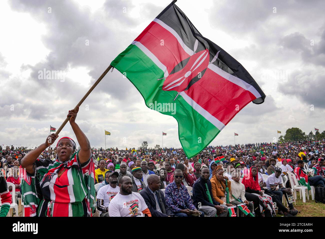 A woman waves a Kenyan flag during the 60th Jamhuri Day Celebrations ...
