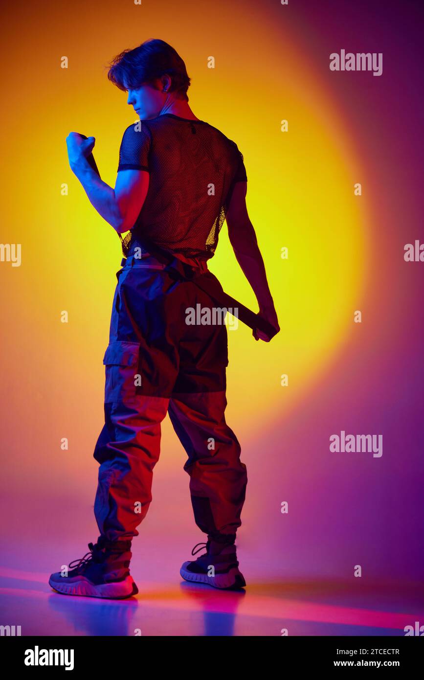 Stylish, handsome young guy in stylish extravagant clothes posing over ...