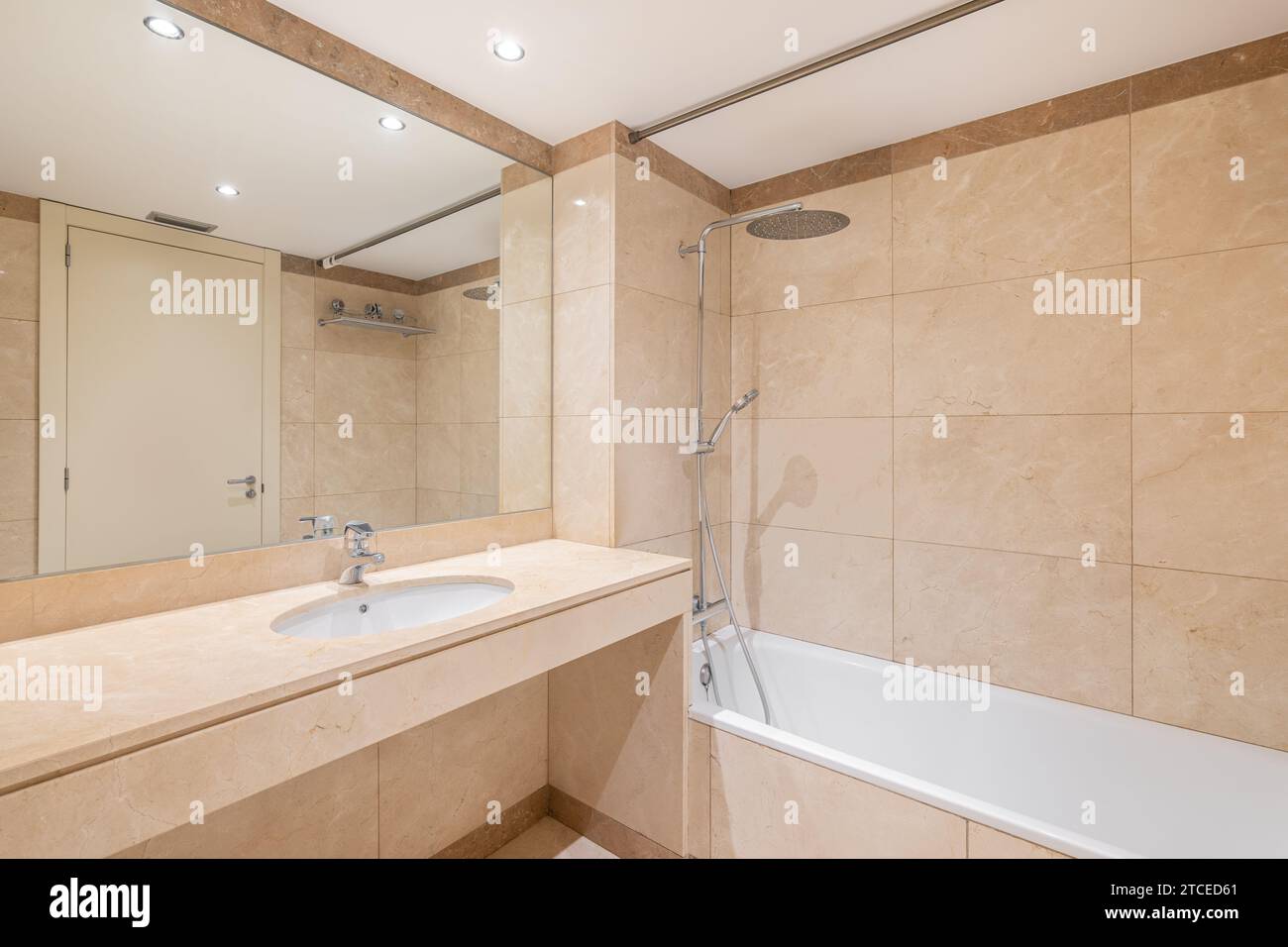 Standard bathroom with bathtub shower system and washbasin Stock Photo ...
