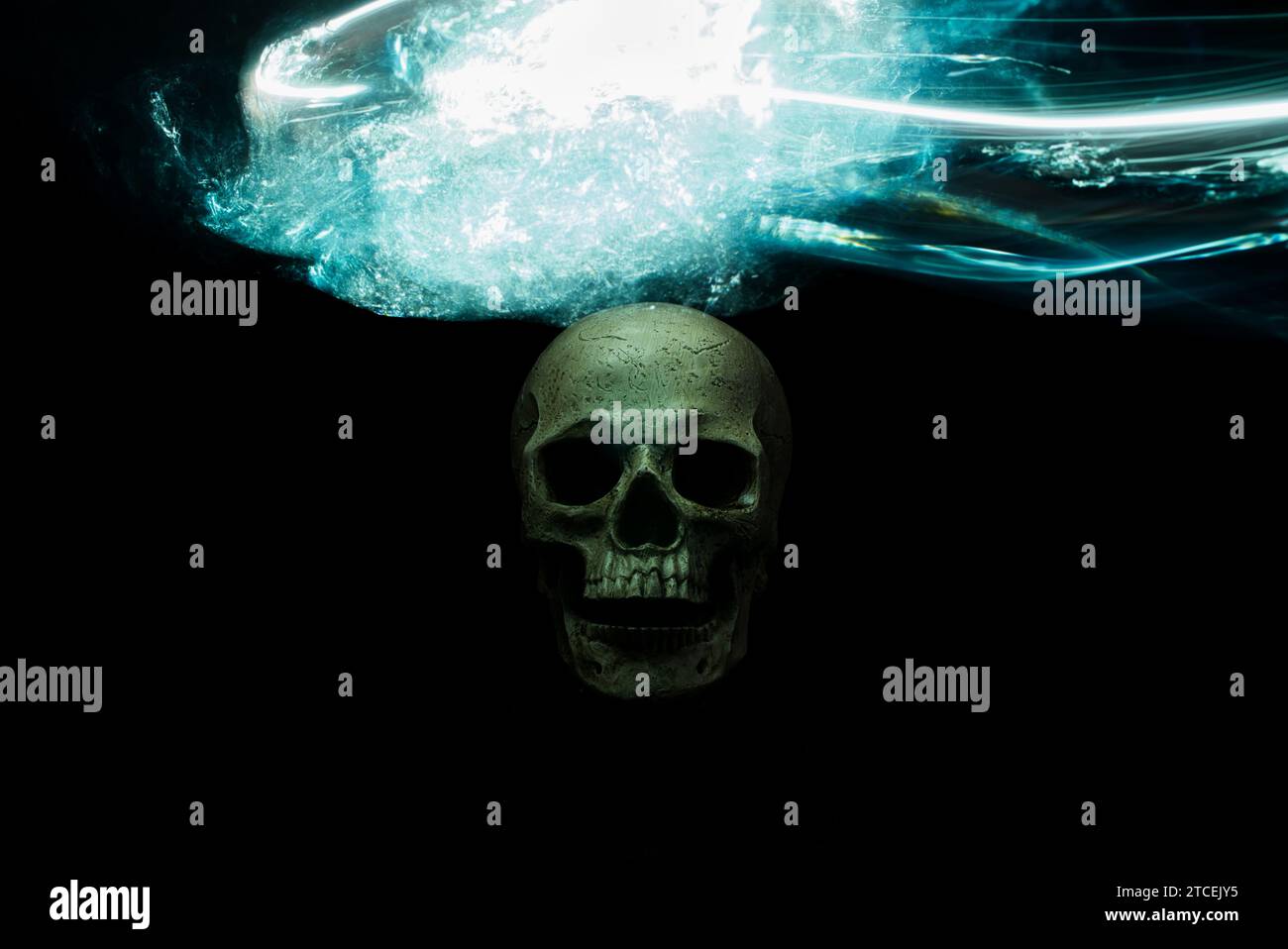 Skull on a black background adorned with dynamic blue-turquoise light ...