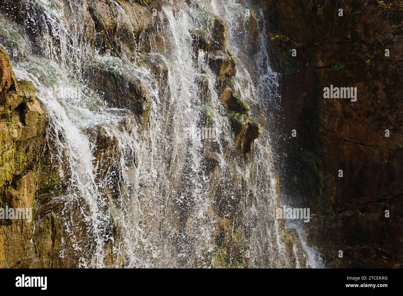 Beautiful waterfall between large rocks in the autumn forest ...
