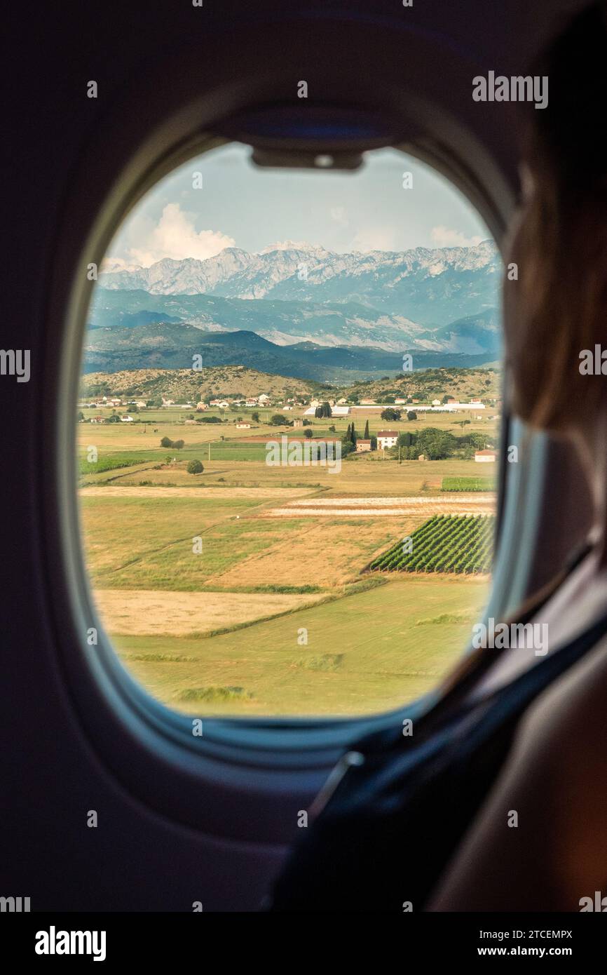 Women looking throw teh window in airplane, during landing in ...