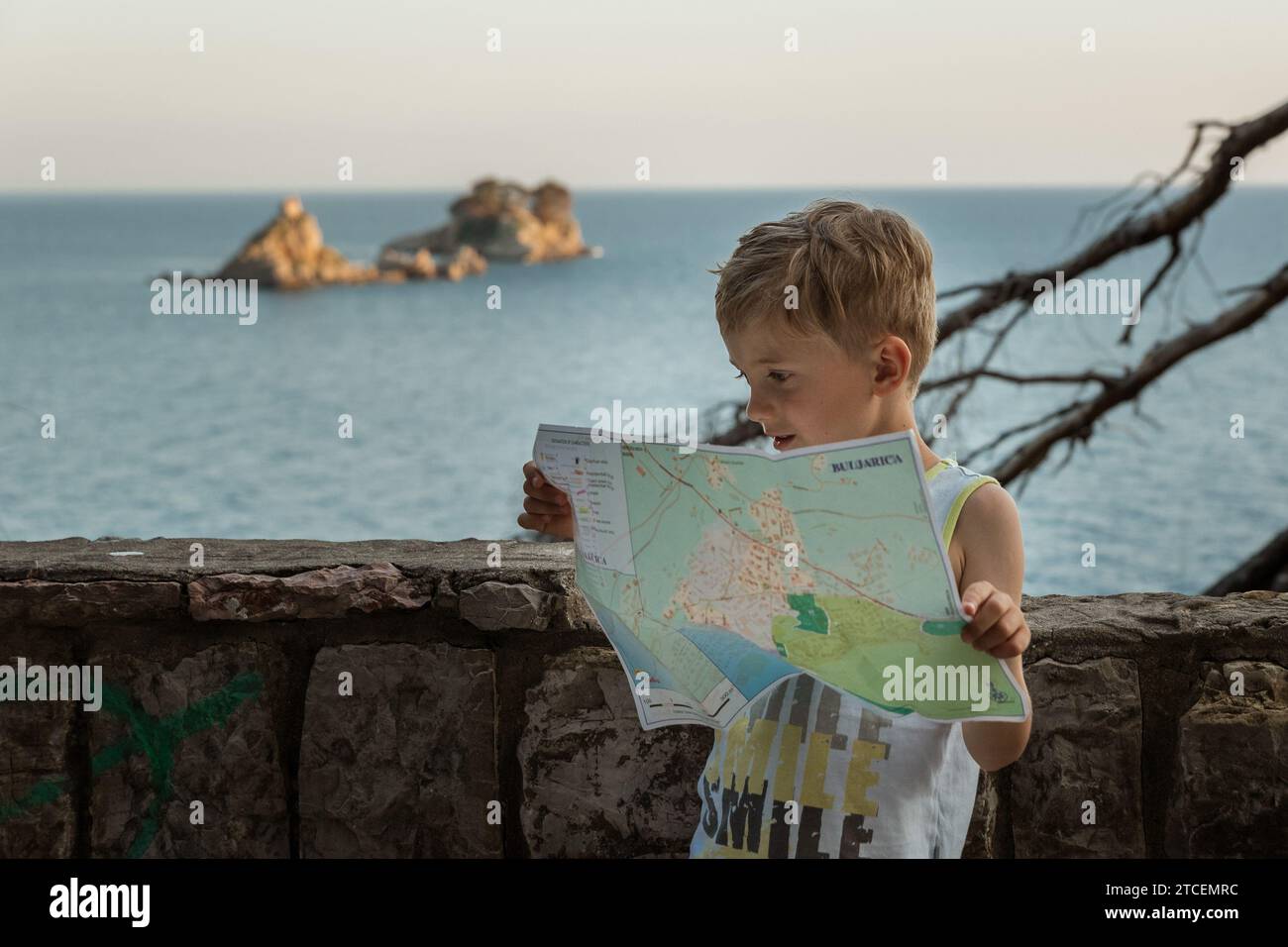Boy looking at the map of Buljarica and Petrovac in Montenegro and ...
