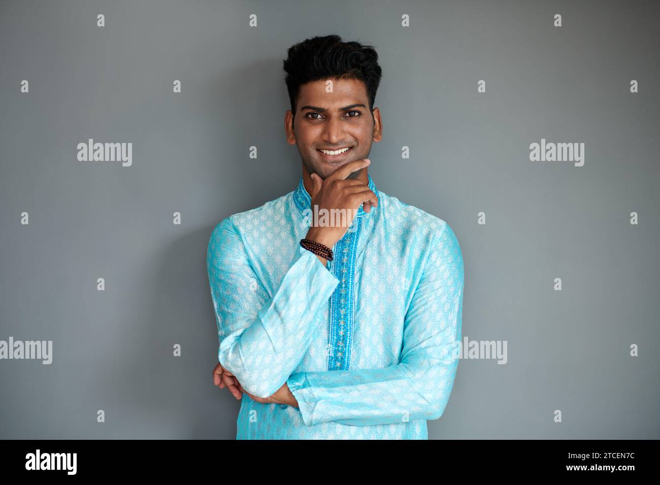 Portrait of confident Indian man in traditional clothes touching chin ...