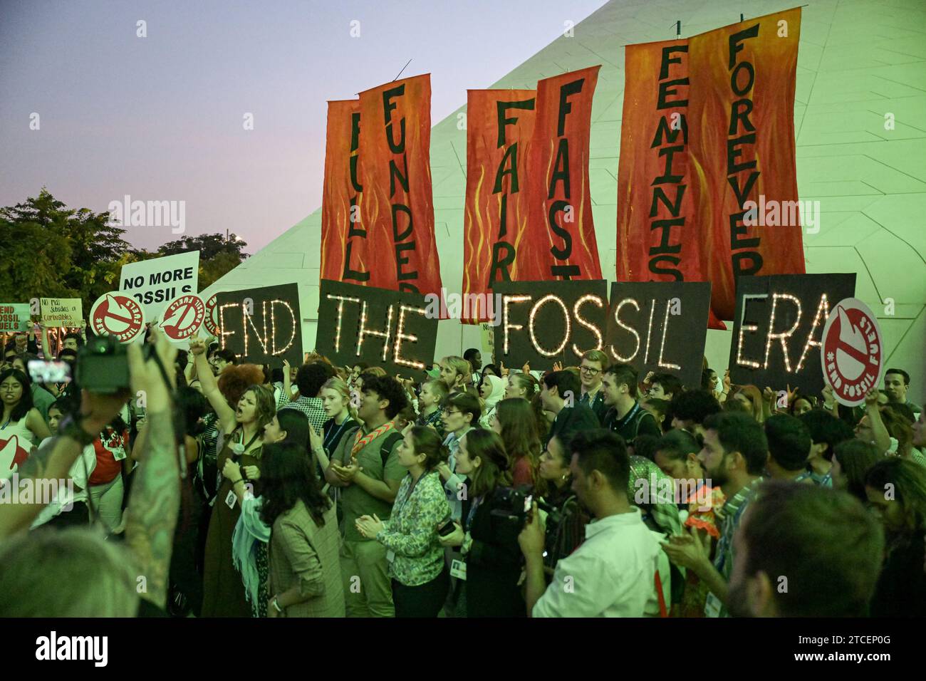 Dubai, United Arab Emirates. 12th Dec, 2023. People hold signs reading ...