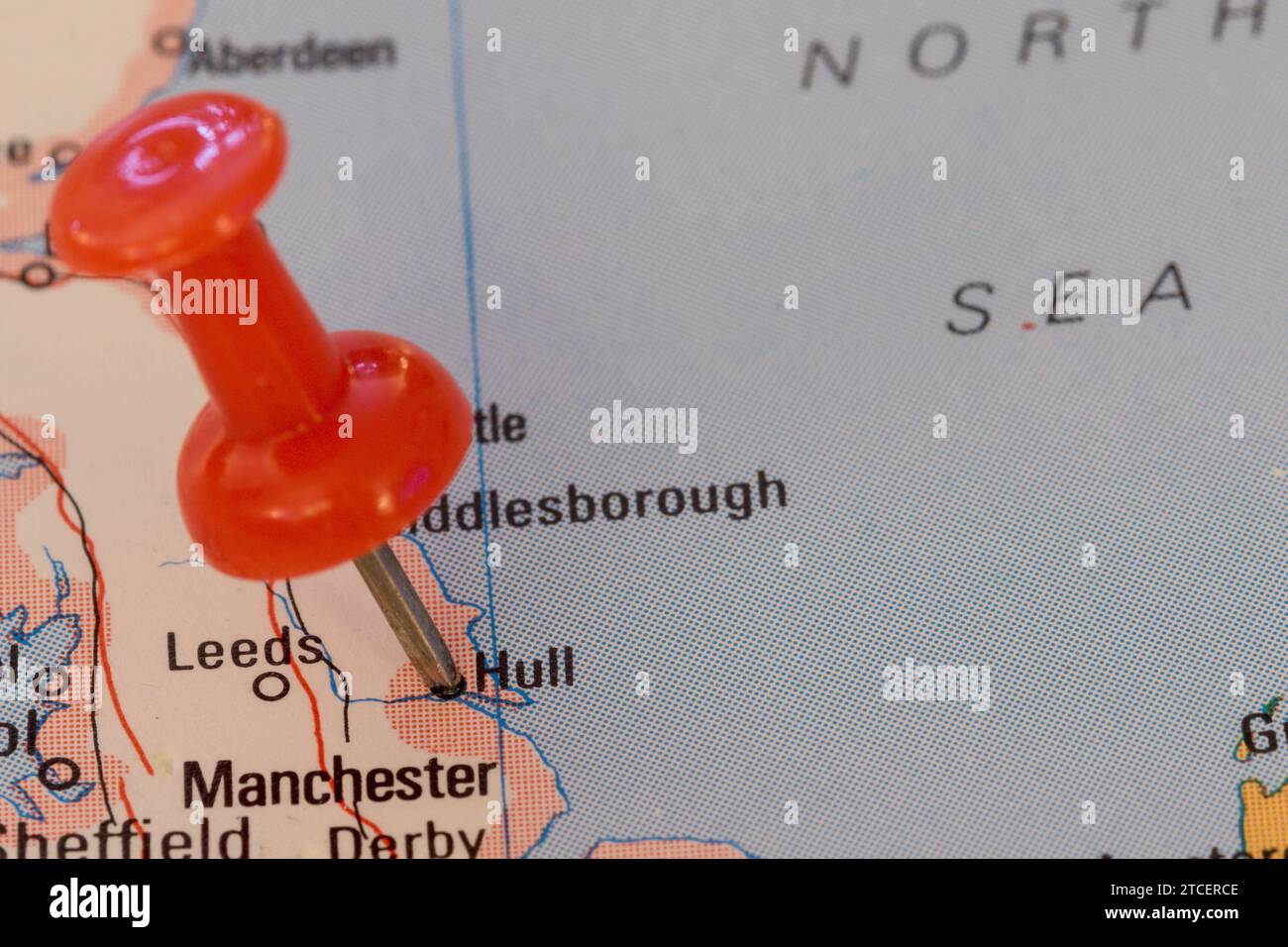 A red pin stuck into a map of Western Europe, pinpointing the location ...