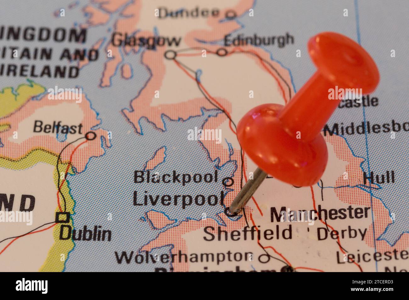 A red pin stuck into a map of Western Europe, pinpointing the location ...