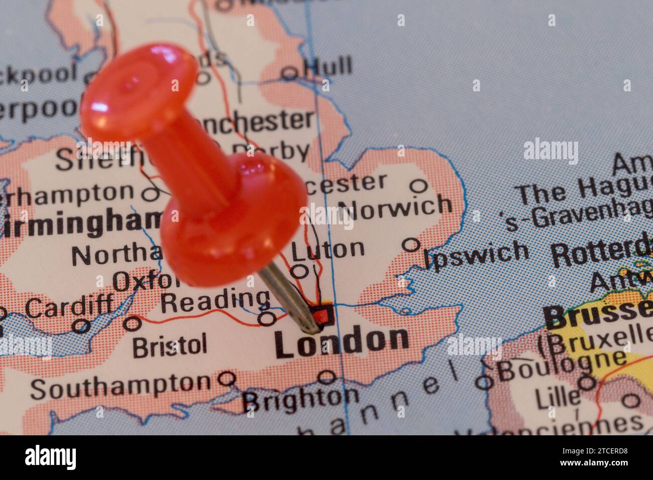 A red pin stuck into a map of Western Europe, pinpointing the location ...