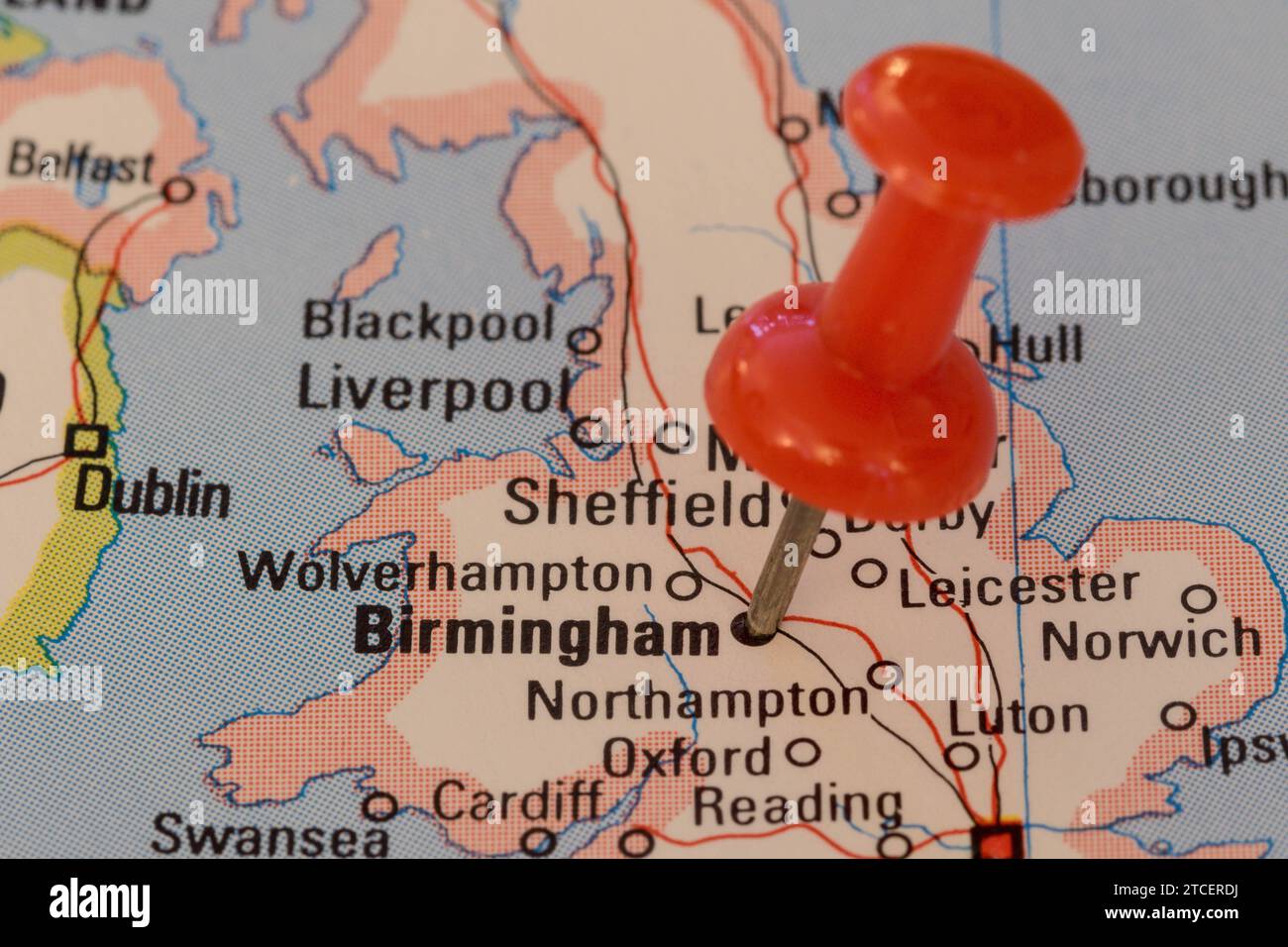 A red pin stuck into a map of Western Europe, pinpointing the location ...