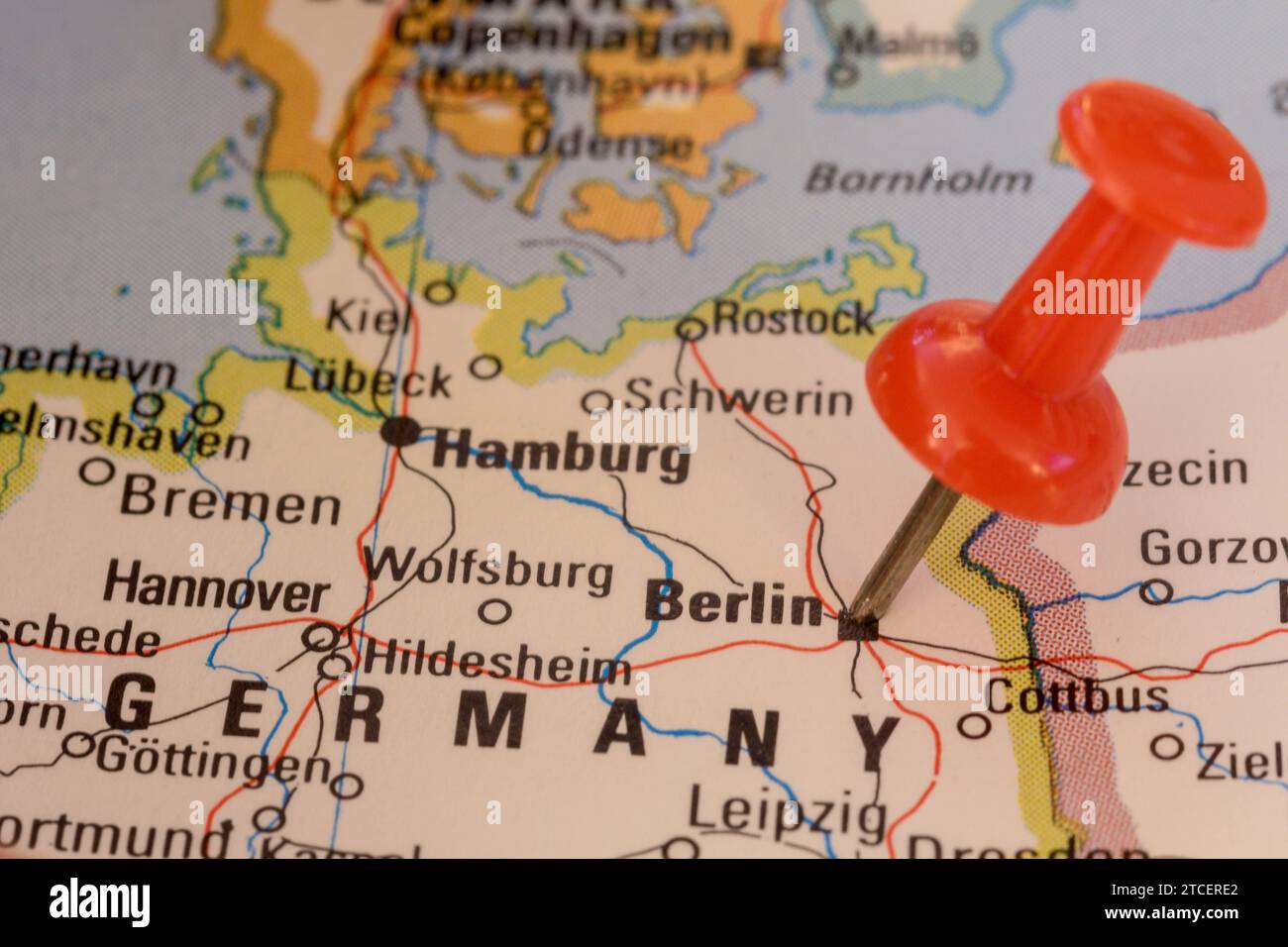 A red pin stuck into a map of Western Europe, pinpointing the location ...