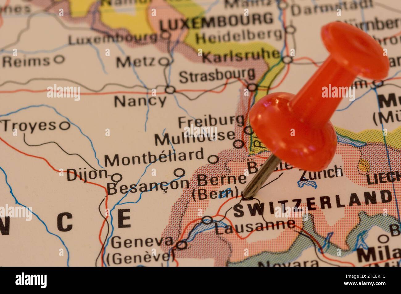 A red pin stuck into a map of Western Europe, pinpointing the location ...