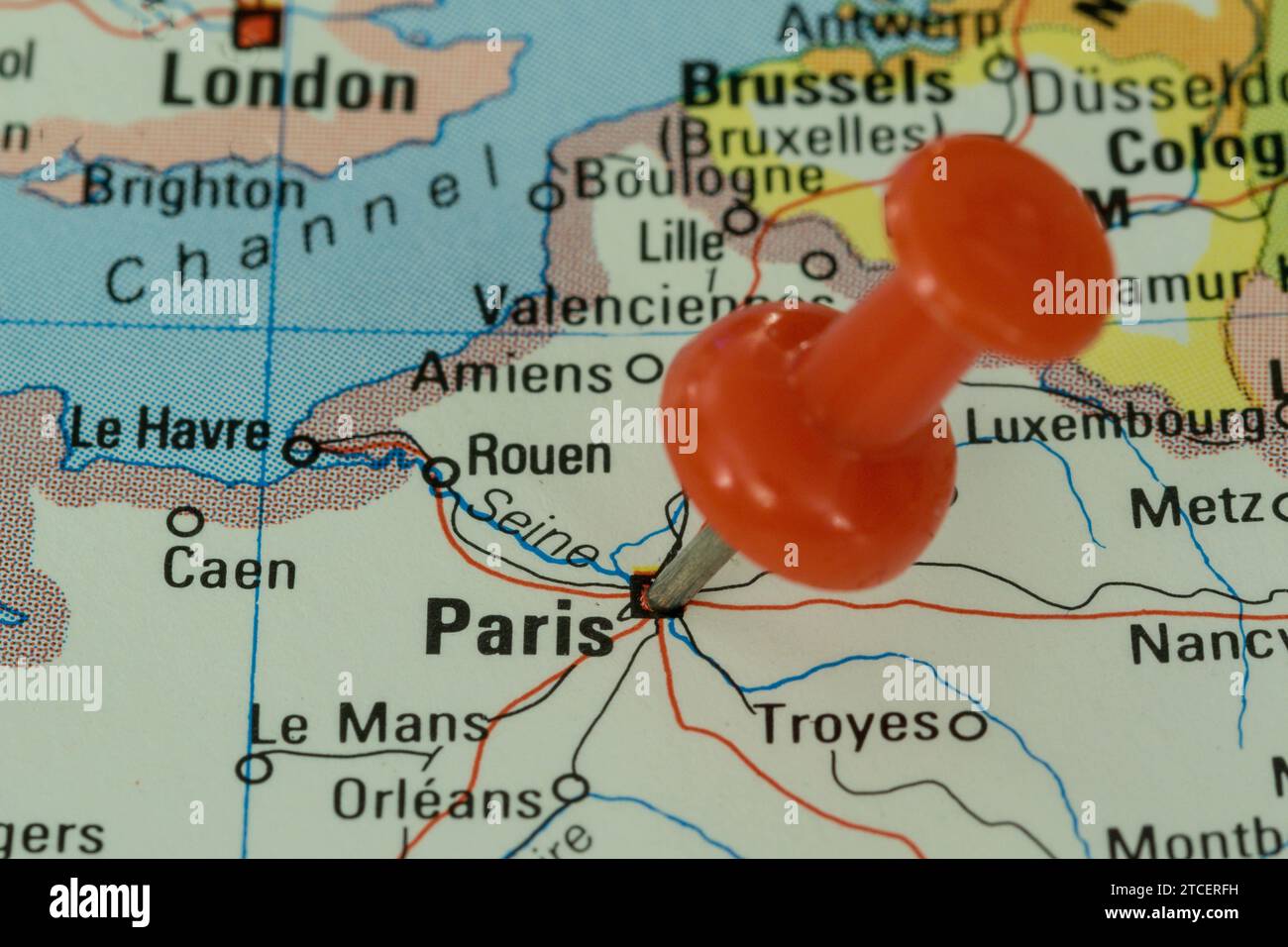 A red pin stuck into a map of Western Europe, pinpointing the location ...