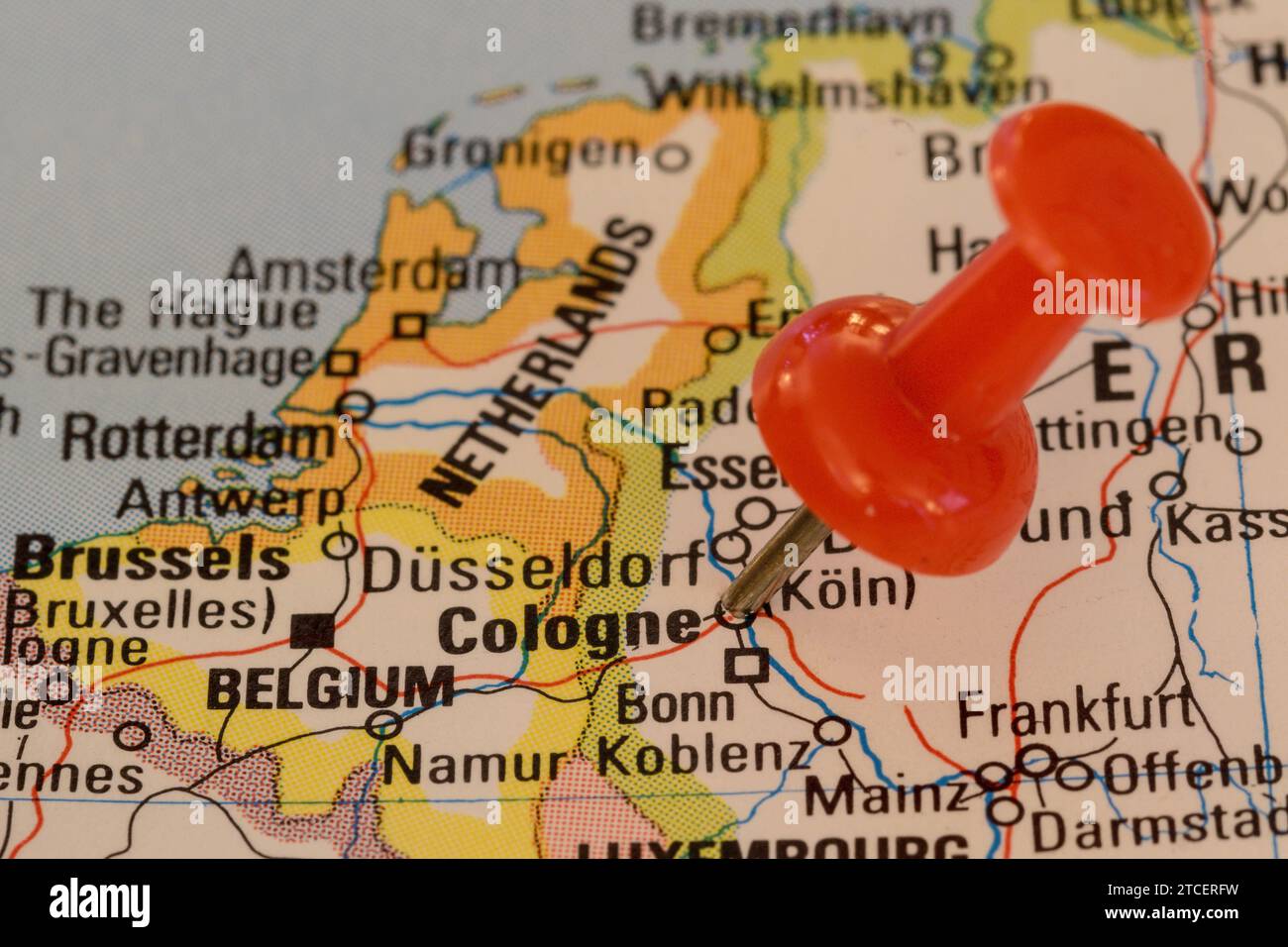 A red pin stuck into a map of Western Europe, pinpointing the location ...