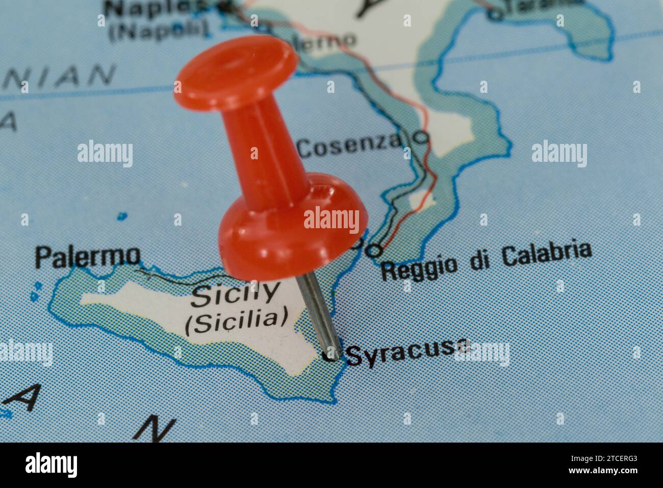 A red pin stuck into a map of Western Europe, pinpointing the location ...