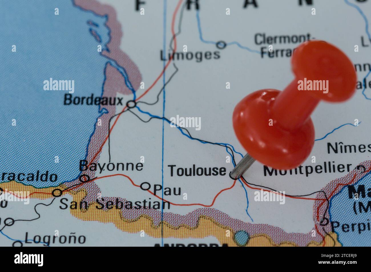 A red pin stuck into a map of Western Europe, pinpointing the location ...