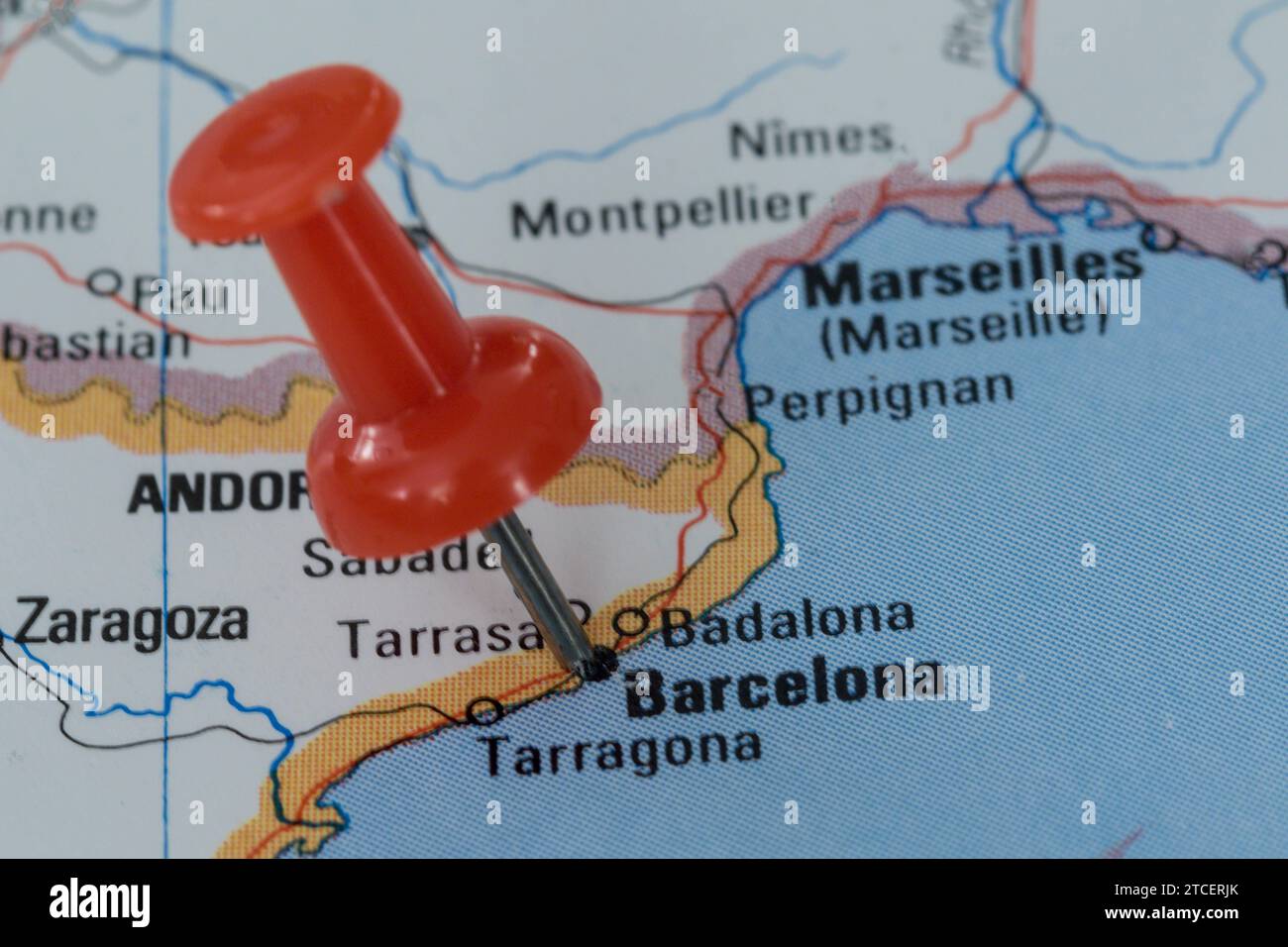 A red pin stuck into a map of Western Europe, pinpointing the location ...