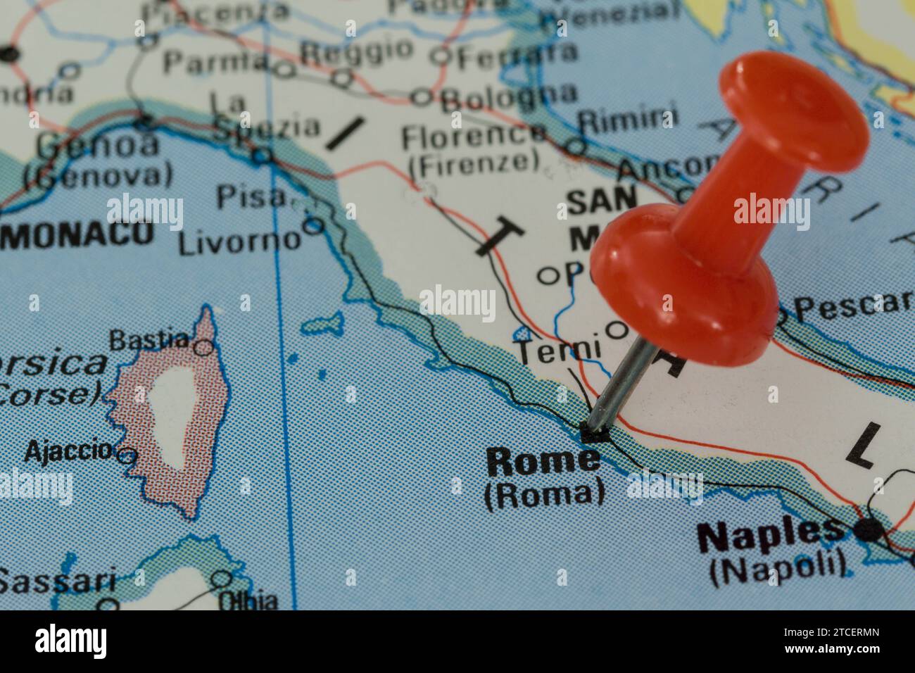 A red pin stuck into a map of Western Europe, pinpointing the location ...