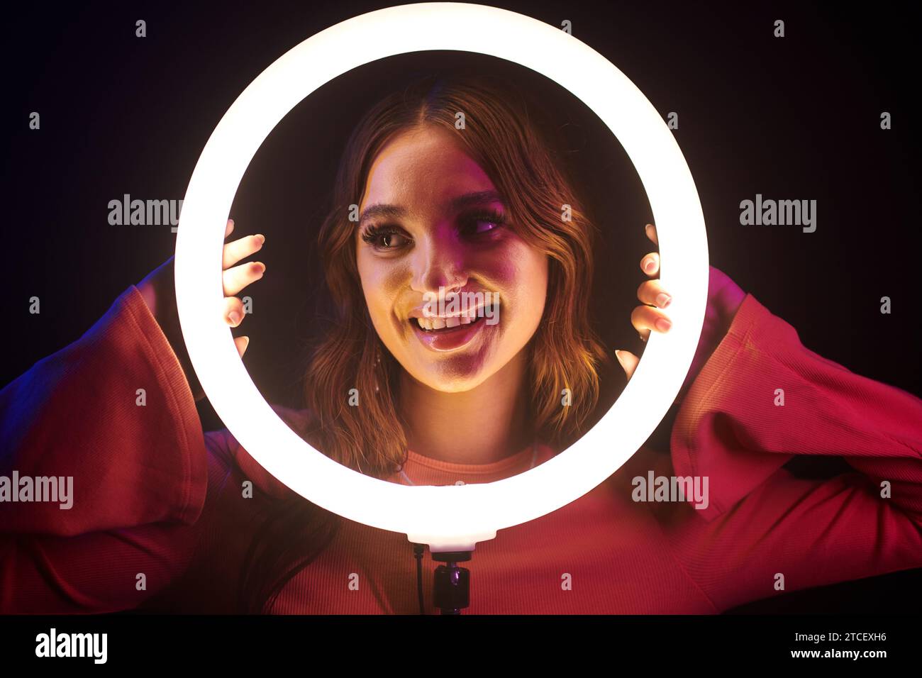 Happy young influencer filming short trendy videos with ring light ...