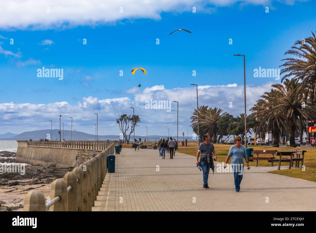 Pedestrians stroll along the popular Sea Point promenade in Cape Town ...
