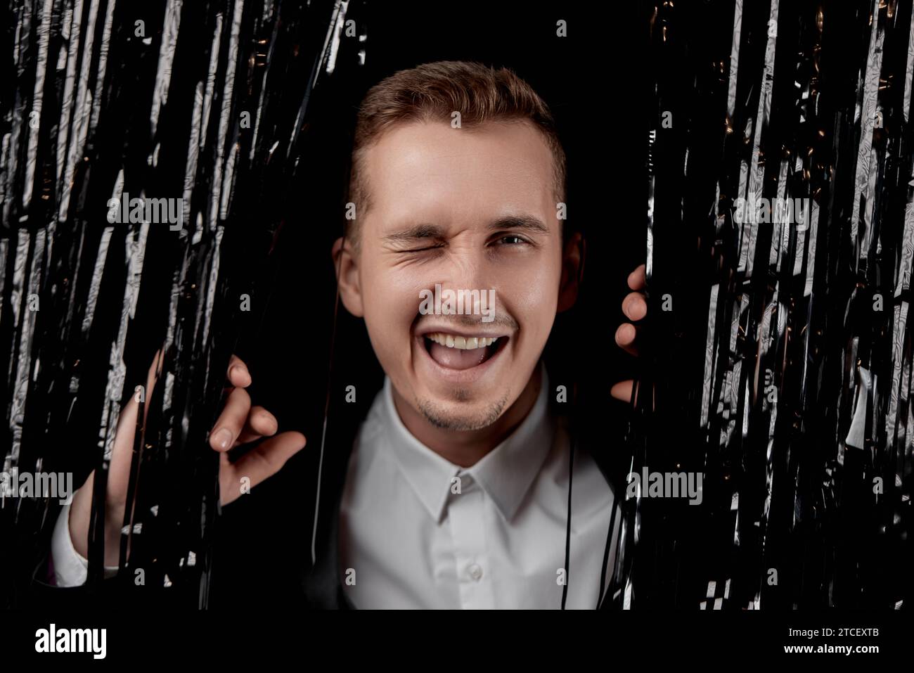 handsome man in black suit winking looking at the camera with happy ...