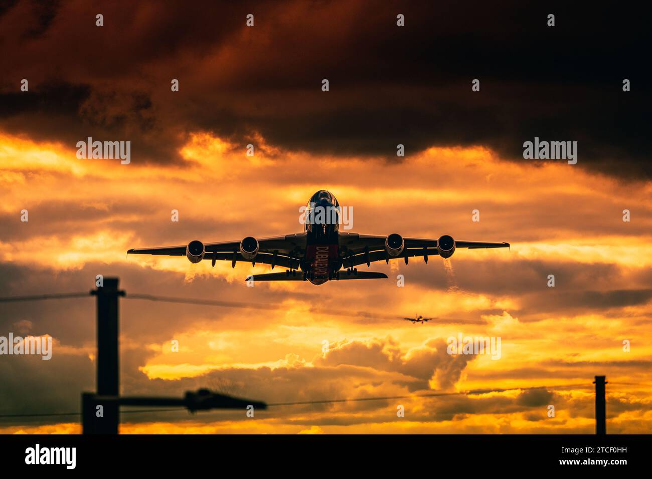 Airbus a380 taking off with a sunset behind it, with fume trails coming ...