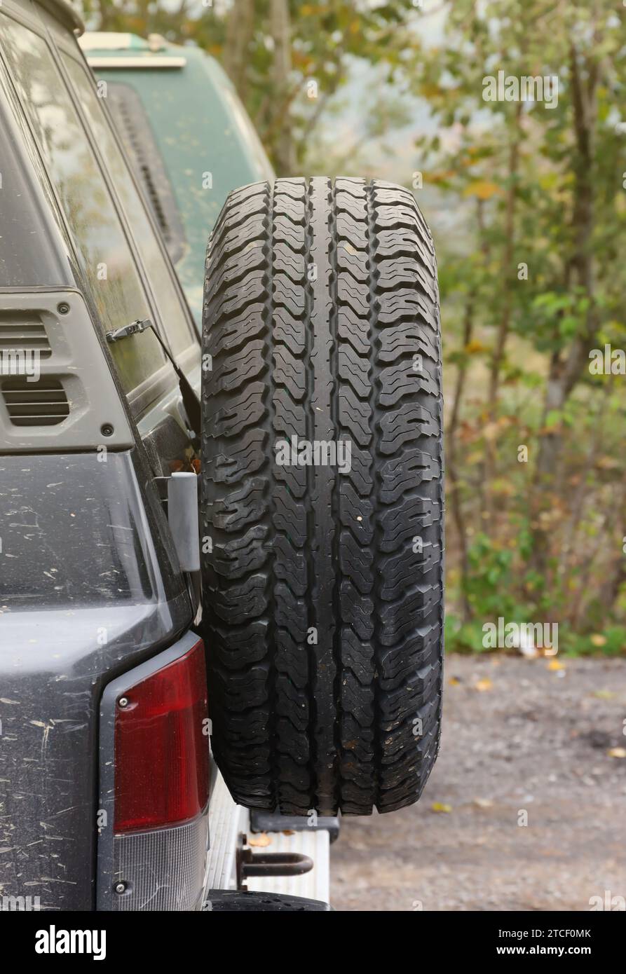 Wheel closeup in a countryside landscape with a mud road. Off-road 4x4 ...