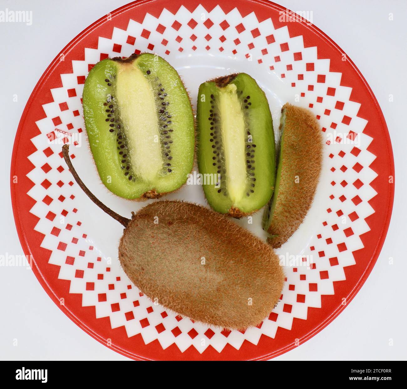 Kiwifruit Actinidia deliciosa 'Hayward' fruit whole and sliced on a red ...