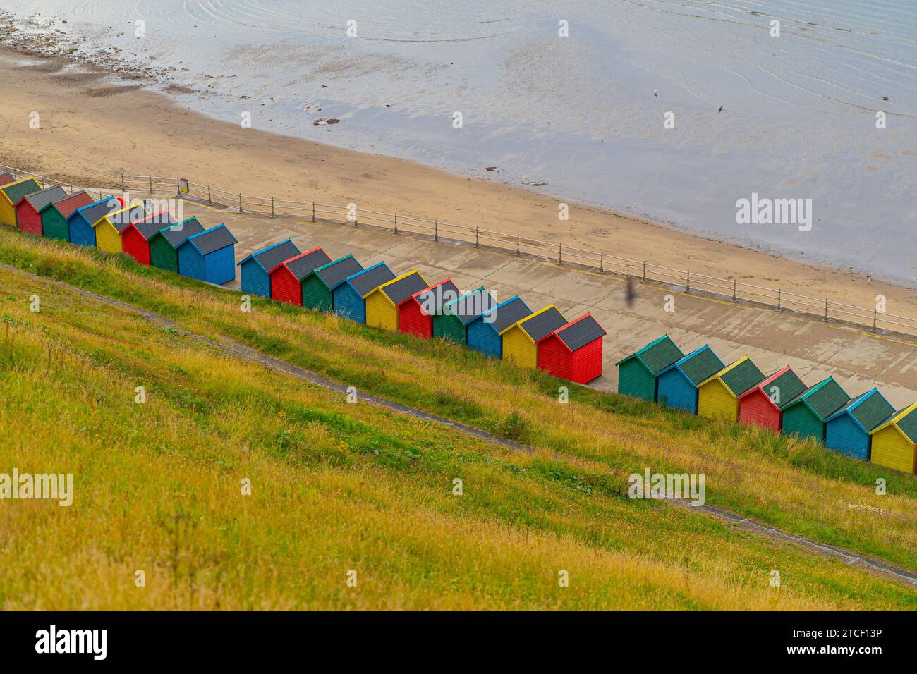 Seaside rainbow coloured huts on the coast of Whitby, UK Stock Photo ...
