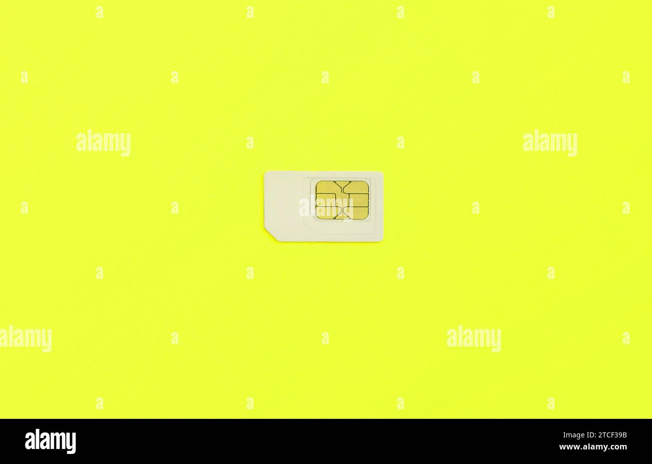 Subscriber identity module. New white SIM card on bright yellow color ...